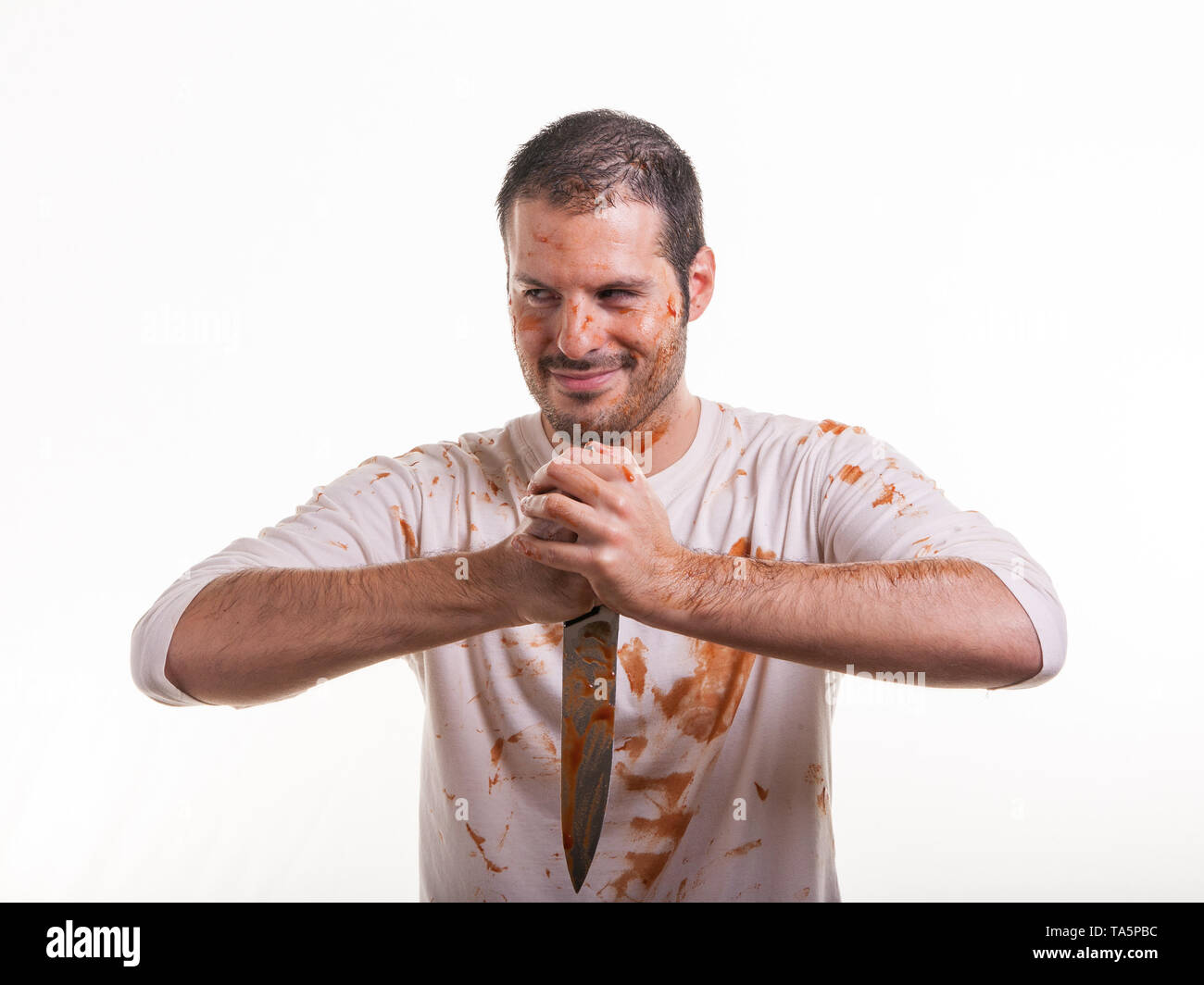 A bloody scene with a man and a blood-covered knife in his hand ...