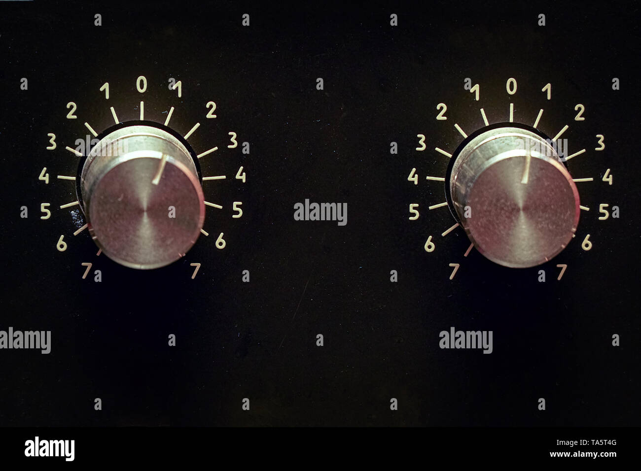 Volume knobs of old amp on black background Stock Photo - Alamy