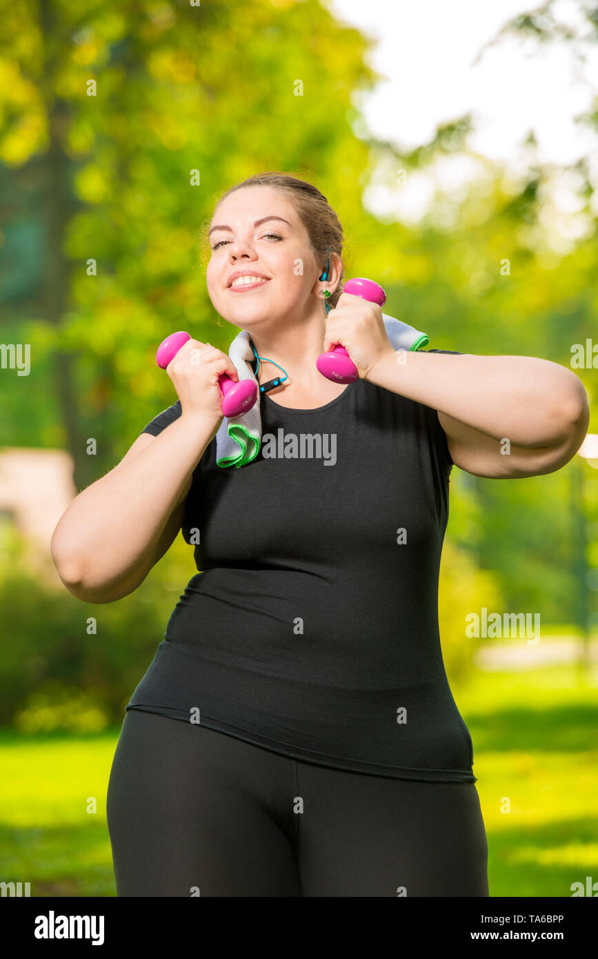 happy plus size model listens to music with headphones and practices ...