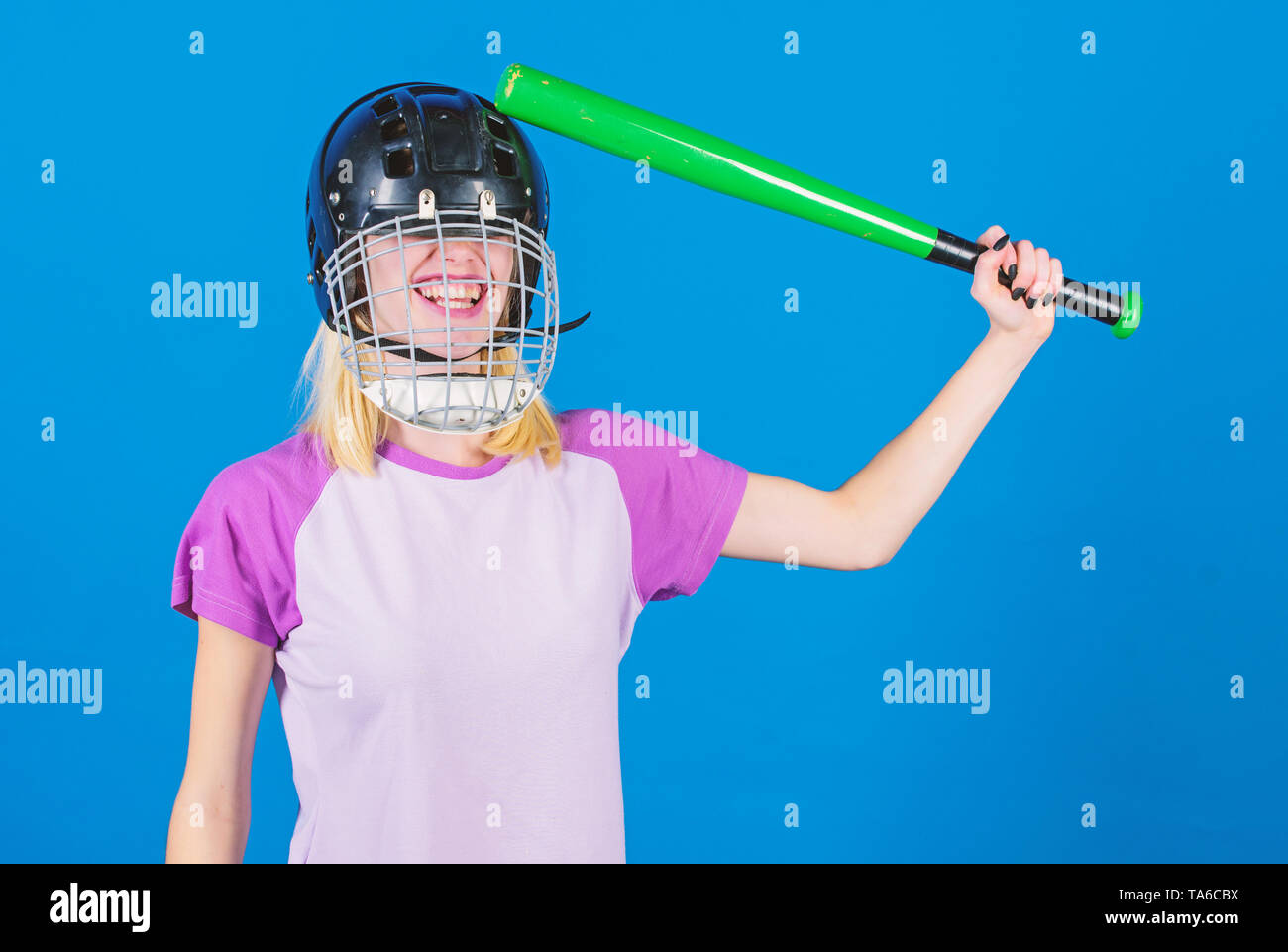 Girl confident pretty blonde wear baseball helmet and hold bat on blue ...