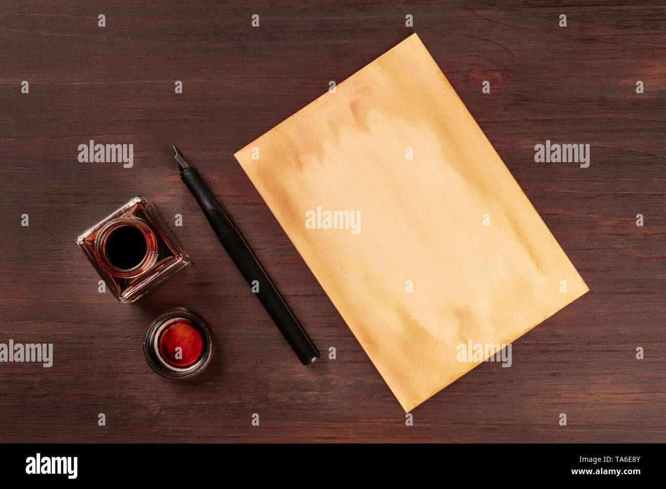 A vintage background with old paper, a nib pen and an ink well, shot ...