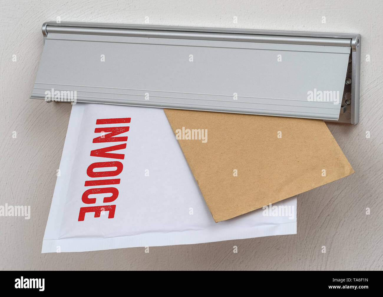 A letter labeled Invoice in a mail slot Stock Photo - Alamy