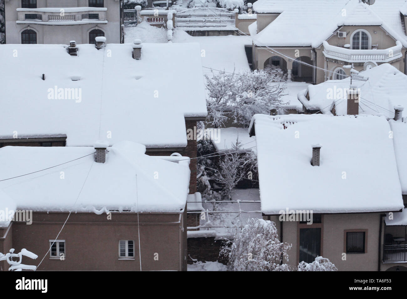 Beautiful winter view of houses and buildings with roofs covered with ...
