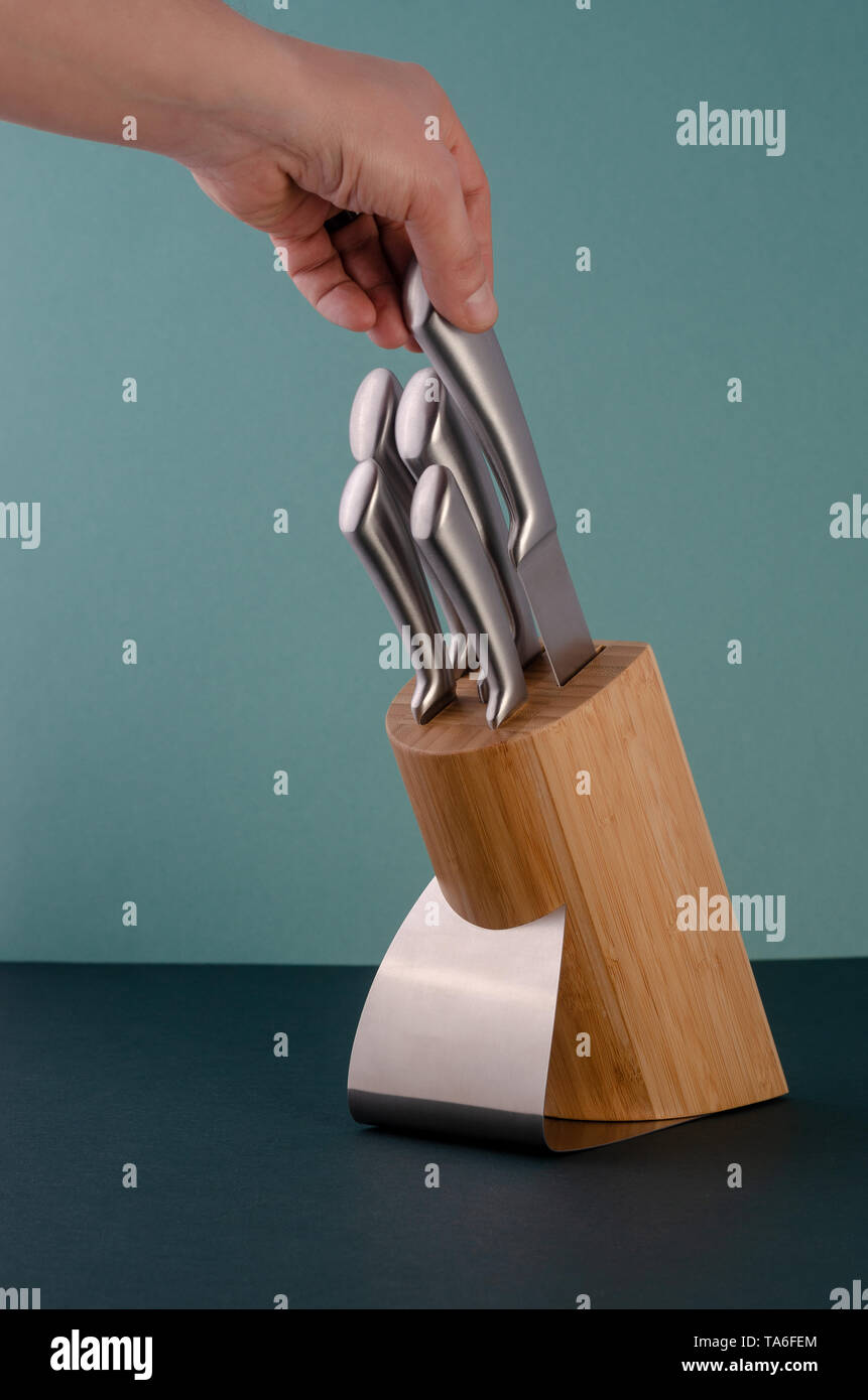 Woman Hands Pulling Out Stainless Steel Chef's Knives From A Bamboo ...
