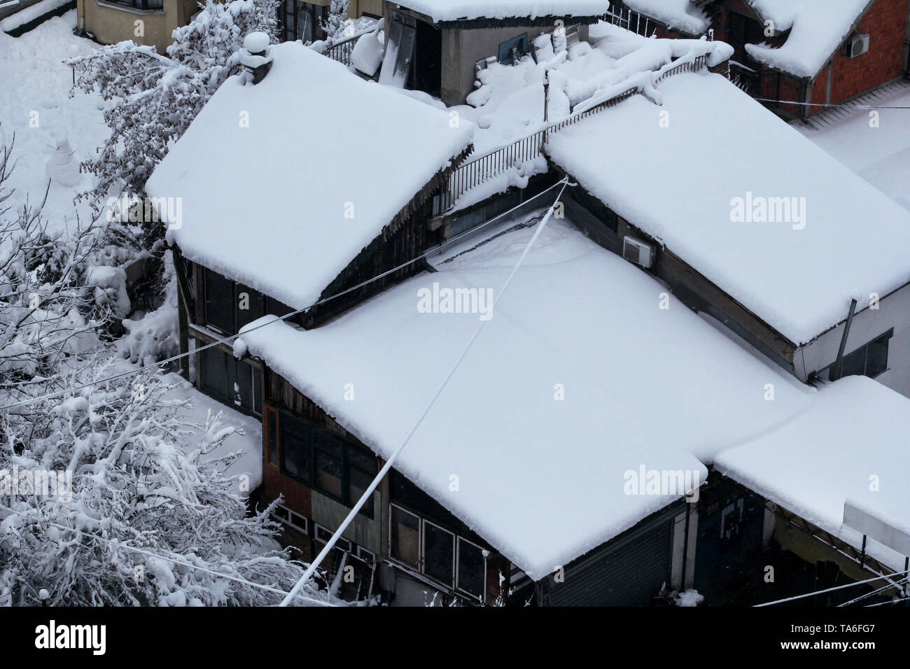 Beautiful winter view of houses and buildings with roofs covered with ...