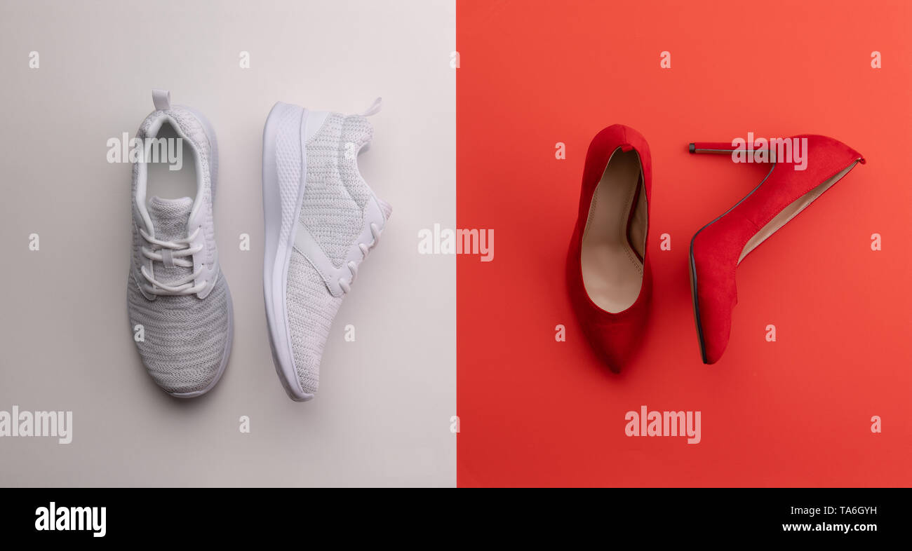 A studio shot of pair of running vs high heel shoes on color background ...