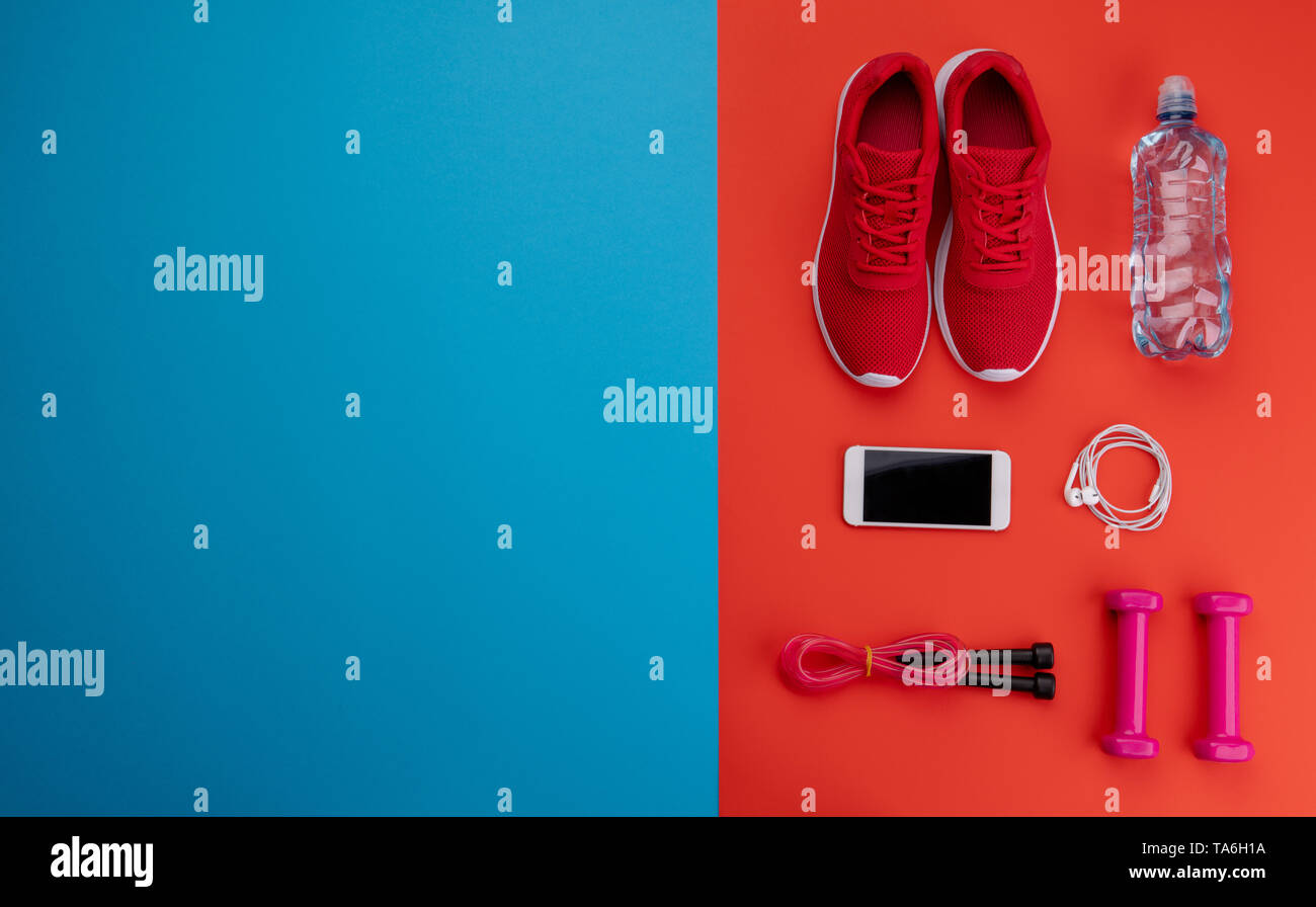 A studio shot of running shoes and other sport equipment on color ...