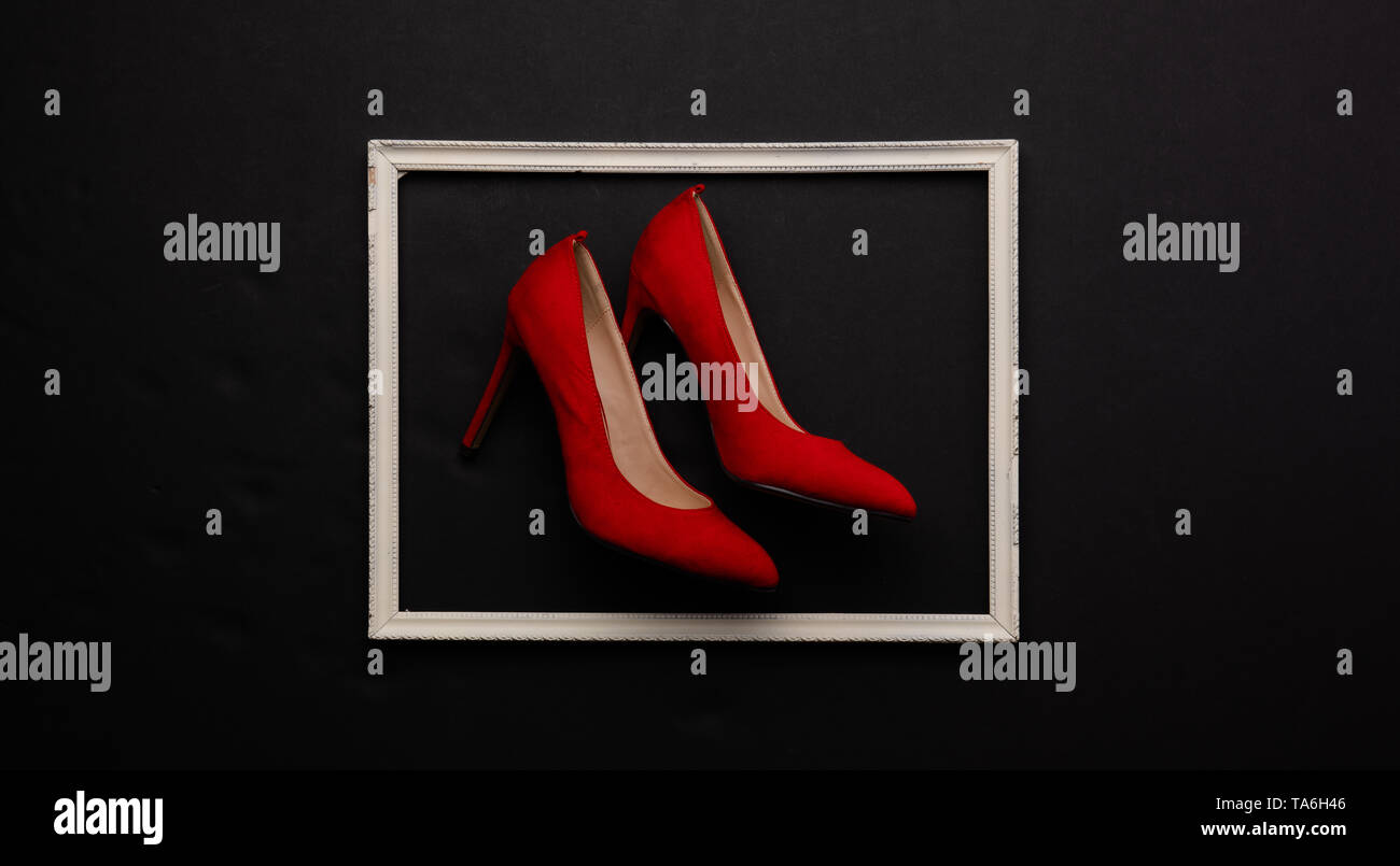 A studio shot of pair of high heel shoes on black background. Flat lay ...