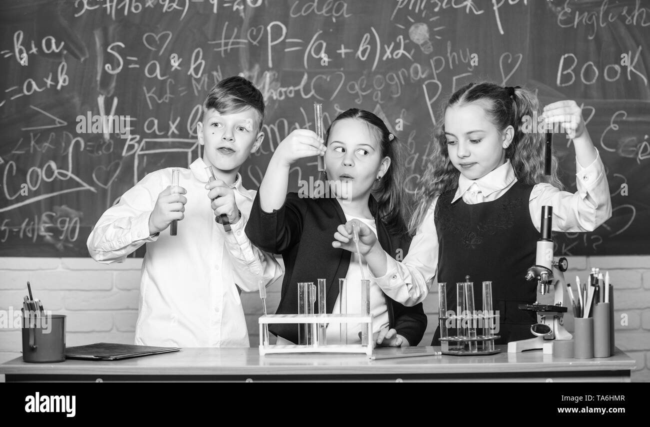 Check result. Girls and boy student conduct experiment with liquids ...