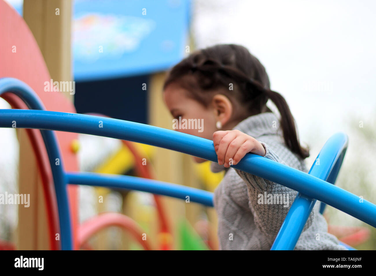 the child climbs the blue welded construction of pipes in the ...