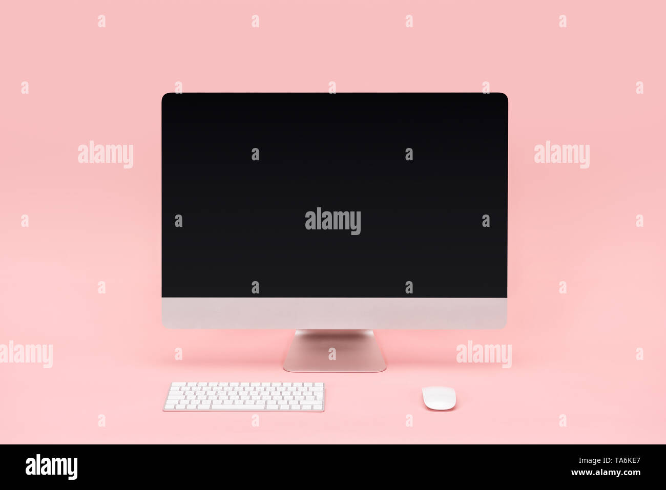 workplace with computer monitor, keyboard and computer mouse on pink ...
