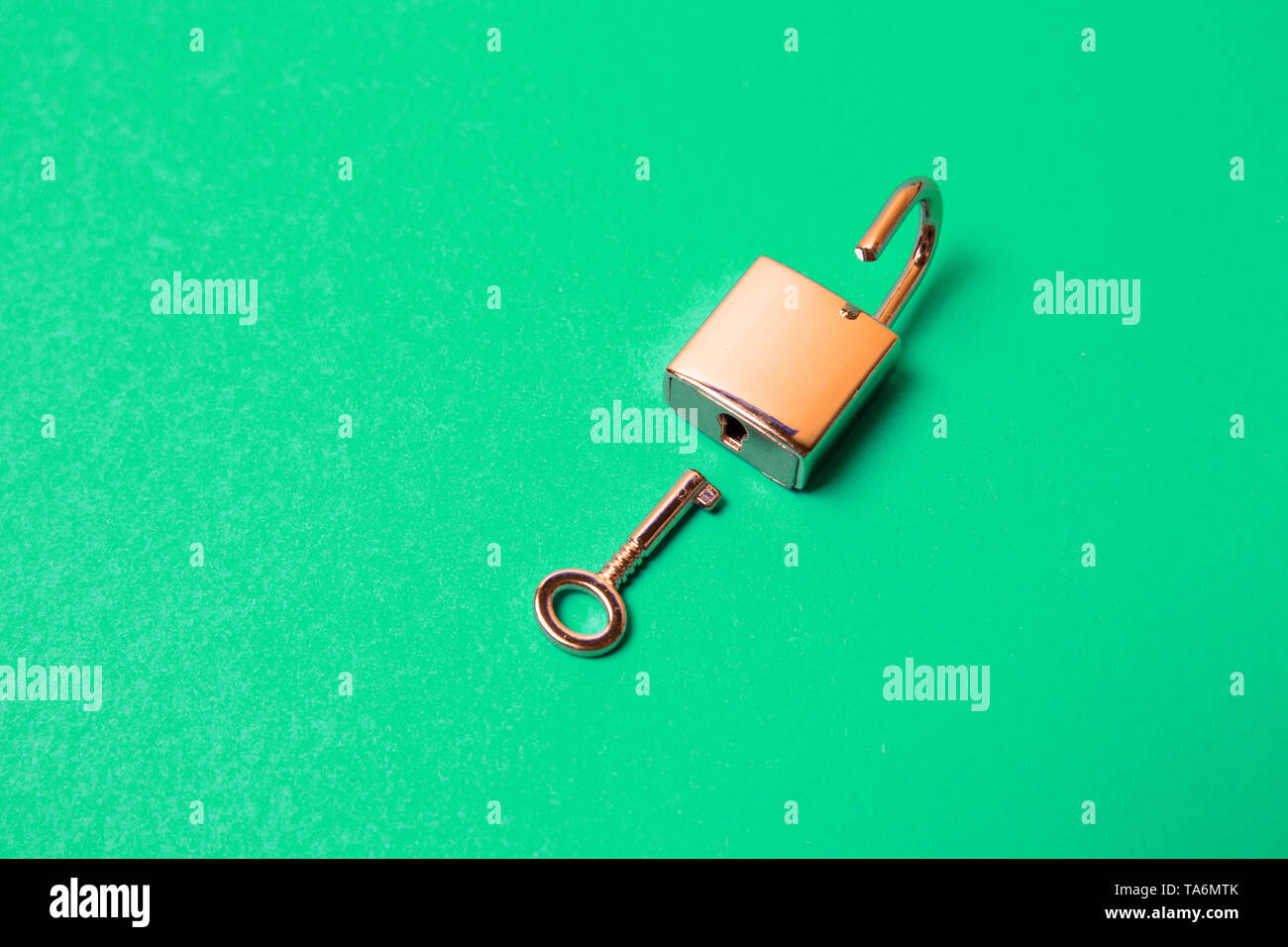 The top view shot of lock and key on a green background Stock Photo - Alamy