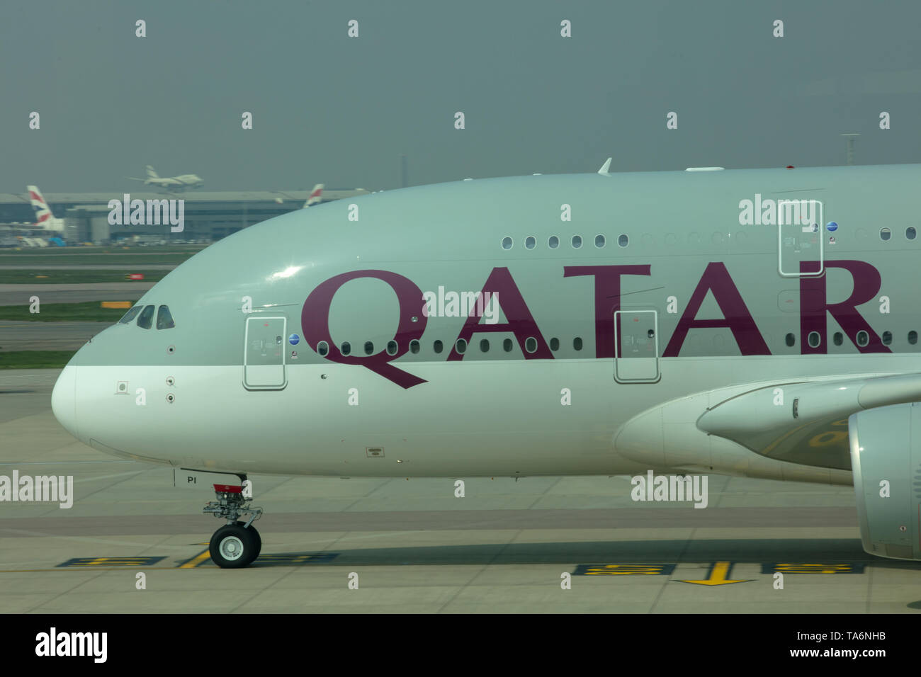 Airplane of Qatar Airways passing slowly on the runway of Heathrow ...