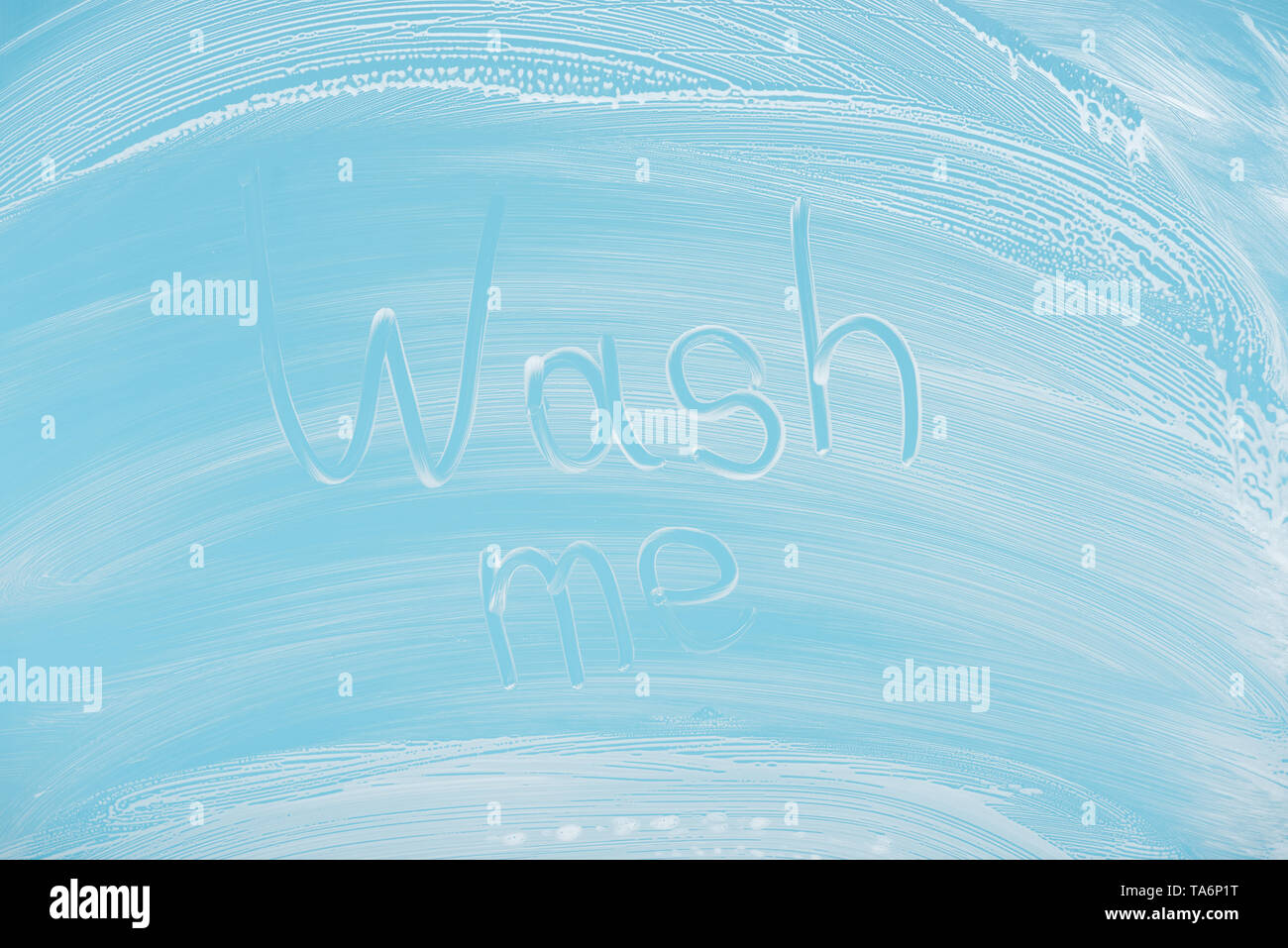 wash me handwritten lettering written on glass with white foam on blue ...
