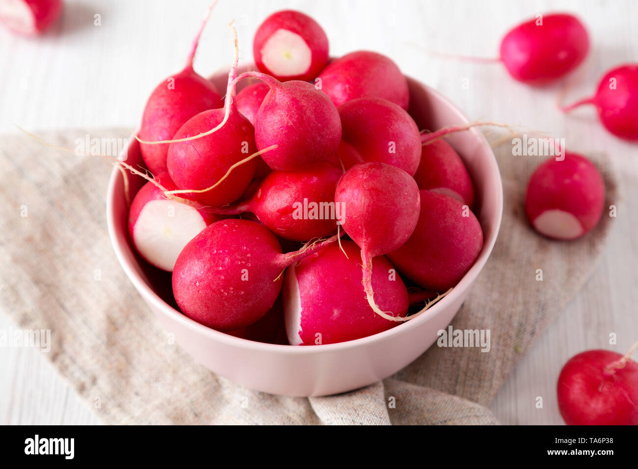 Fresh red radishes in a pink bowl, side view. Closeup Stock Photo - Alamy