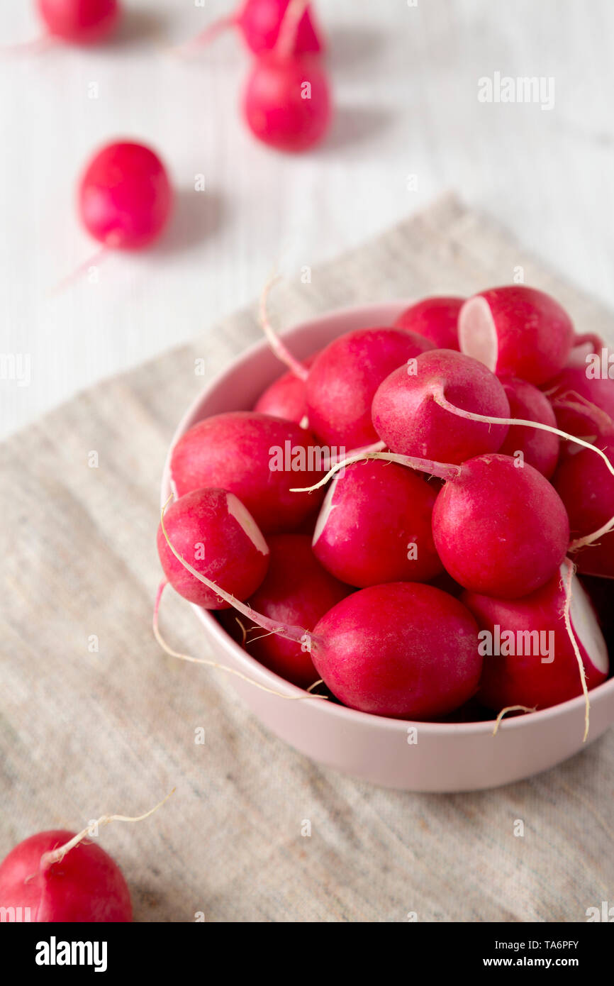 Fresh red radishes in a pink bowl, side view. Close-up Stock Photo - Alamy