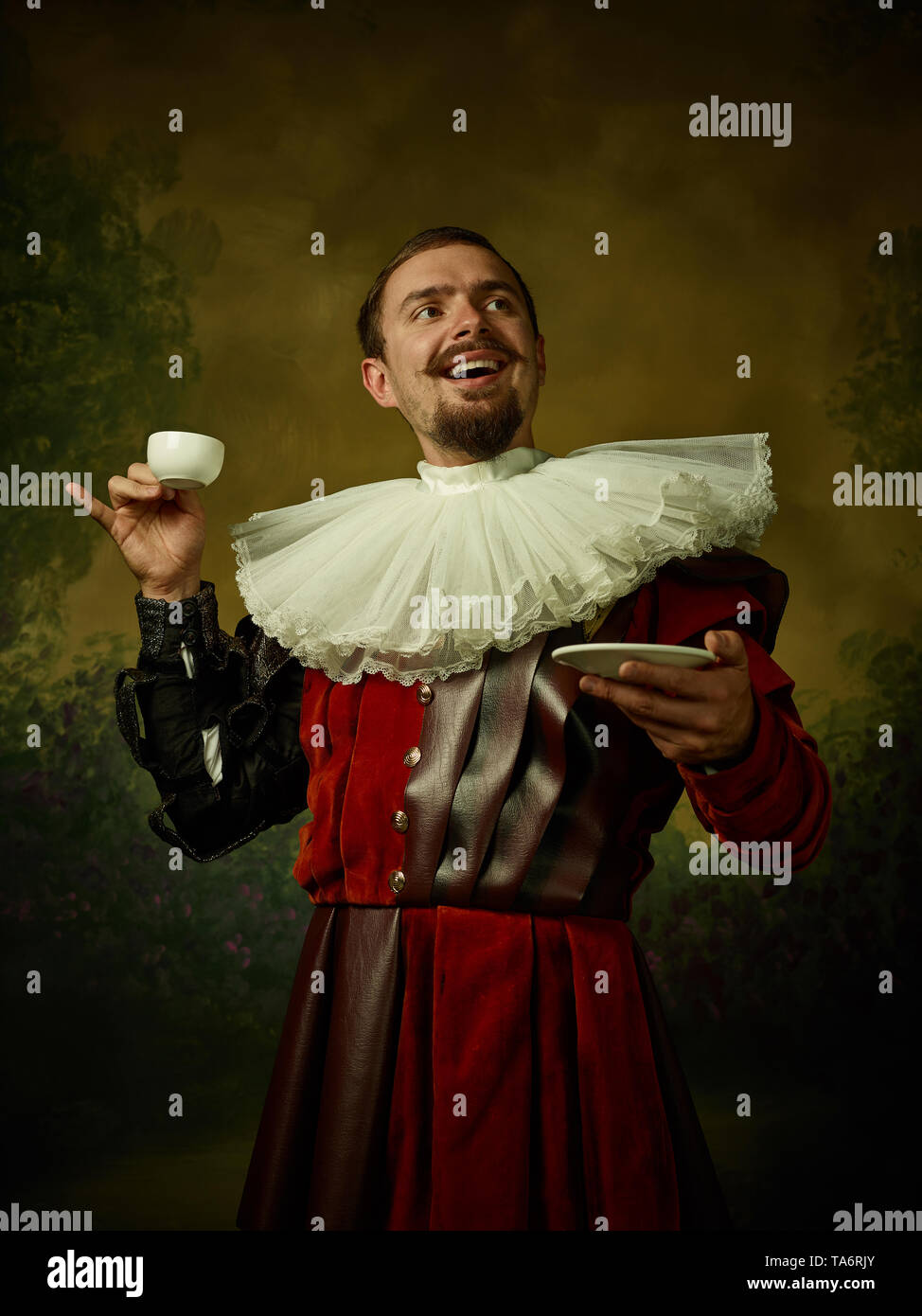 Young man as a medieval knight on dark studio background. Portrait in ...