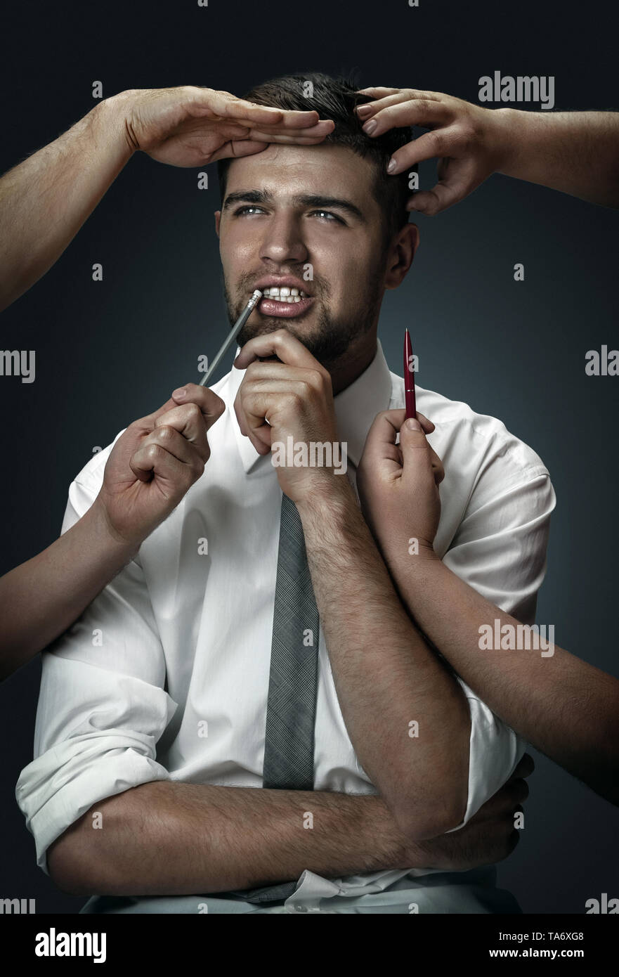 A male model surrounded by hands like his own thoughts on dark ...