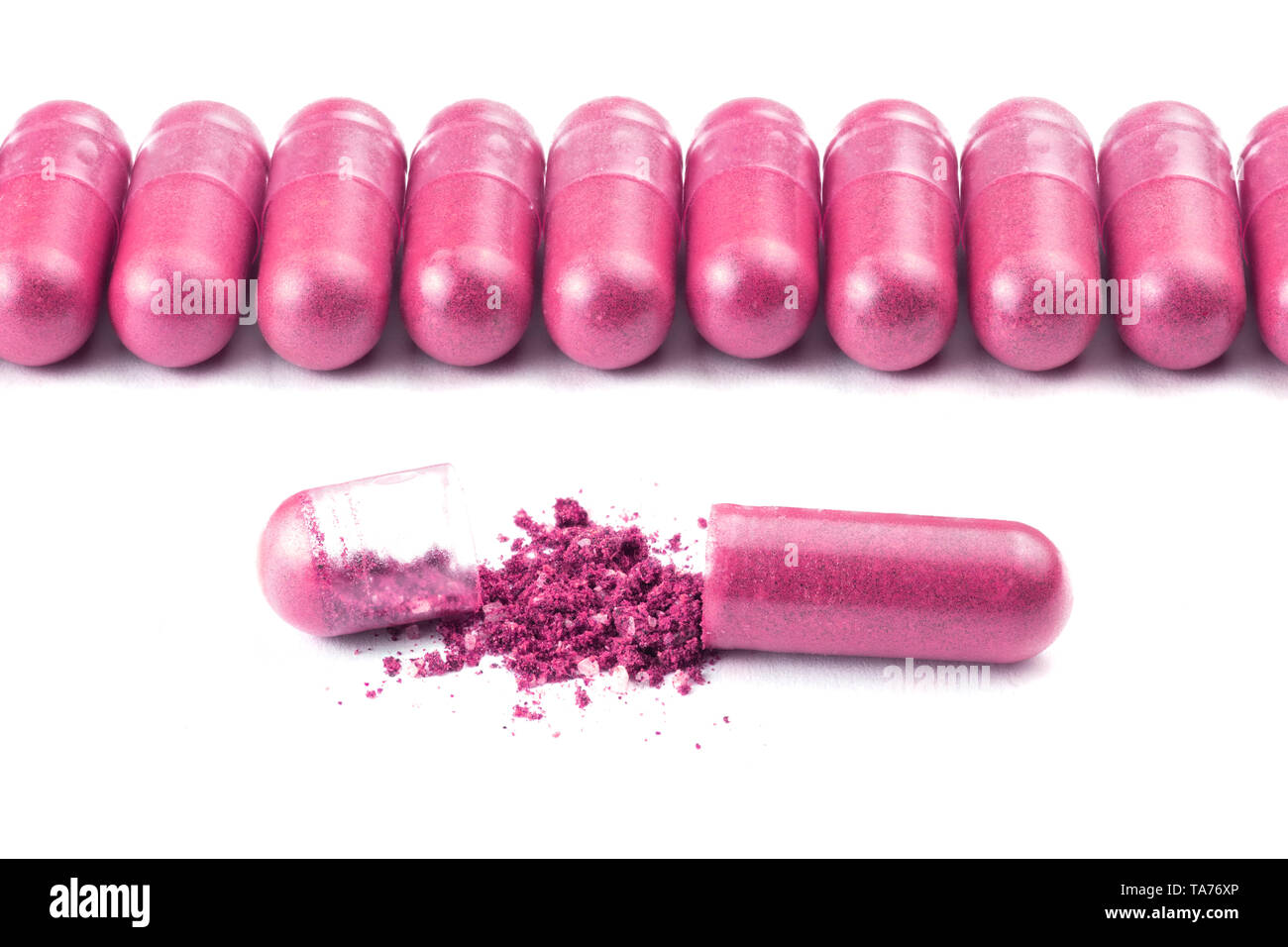 row of plastic pink color organic capsules isolated on white background ...