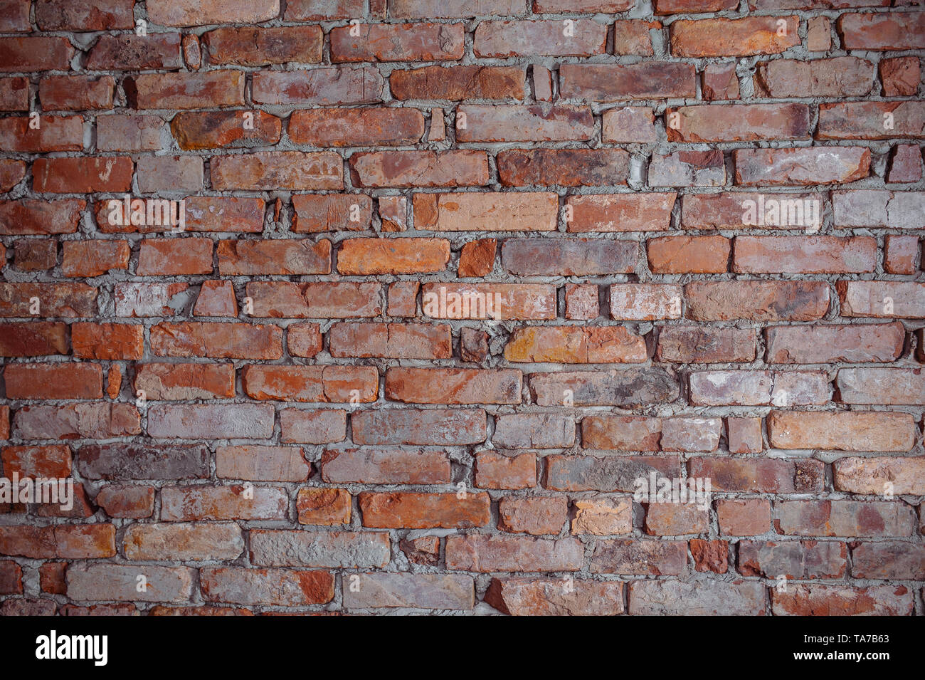 Wall made with brown bricks mixed randomly with small black ones ...