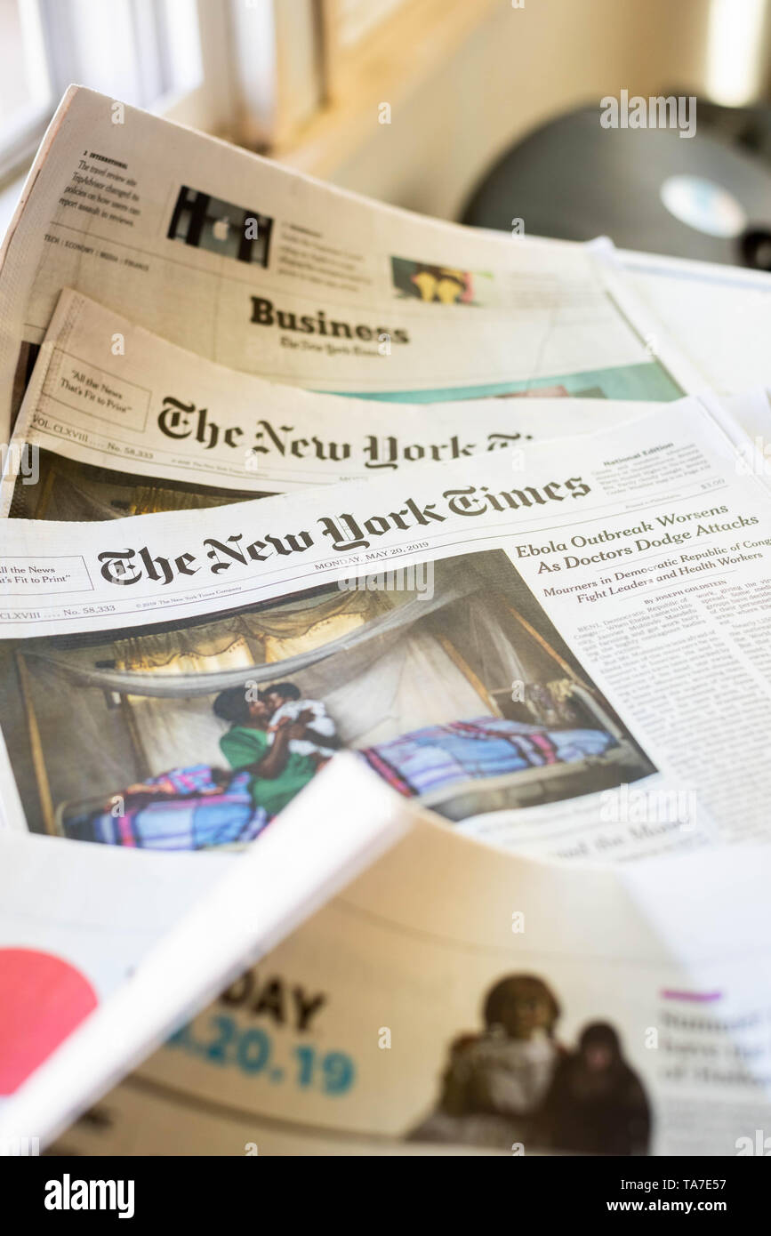 A stack of newspapers, The New York Times and USA Today, lay on a table ...