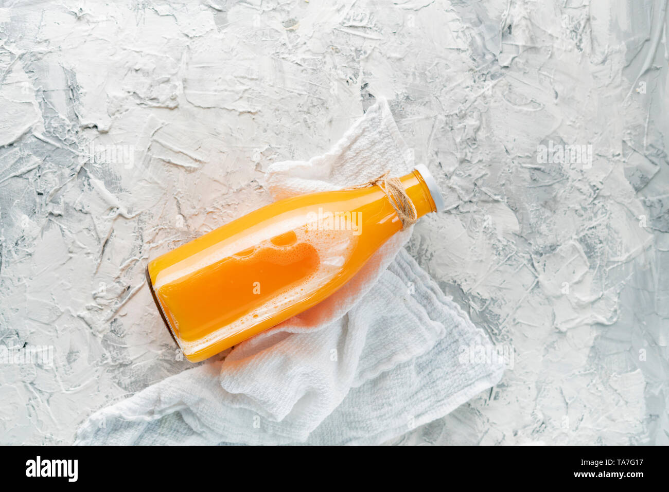 glass bottle with a squeezed orange juice, sliced in a half oranges ...