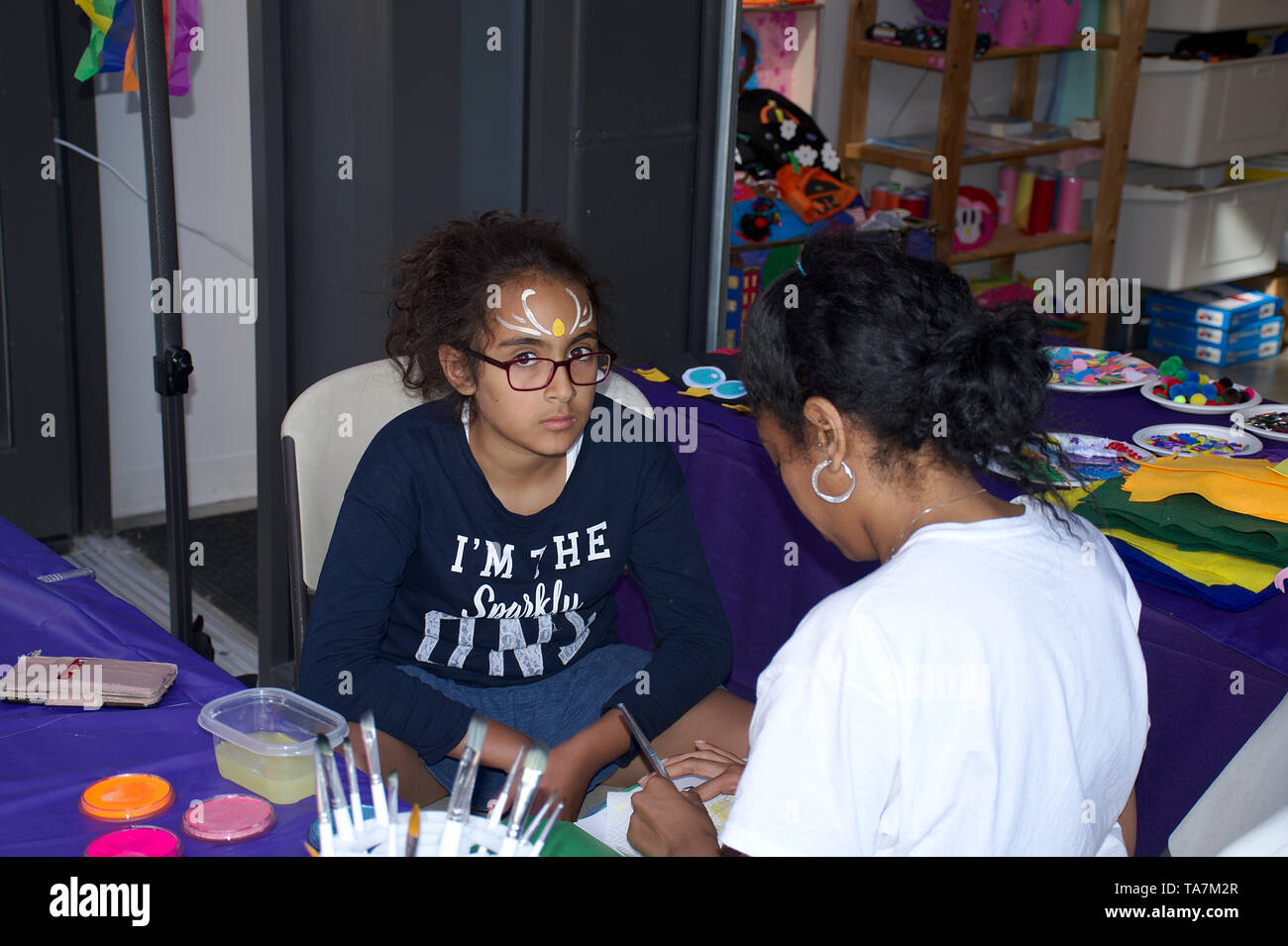 Young female getting face painted Stock Photo - Alamy