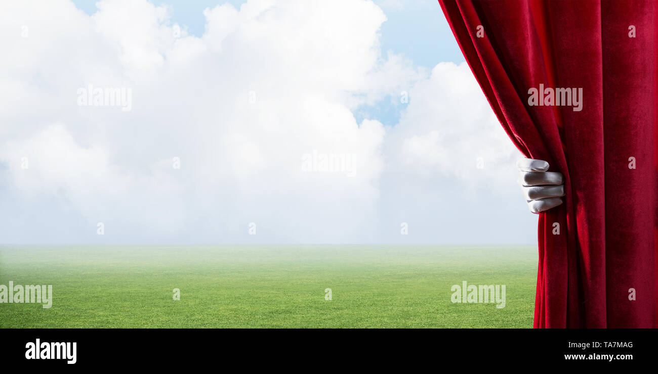 Green meadow behind red curtain and hand holding it Stock Photo - Alamy