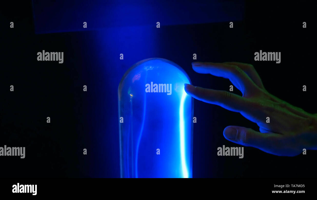 Woman touching plasma glass flask Stock Photo - Alamy