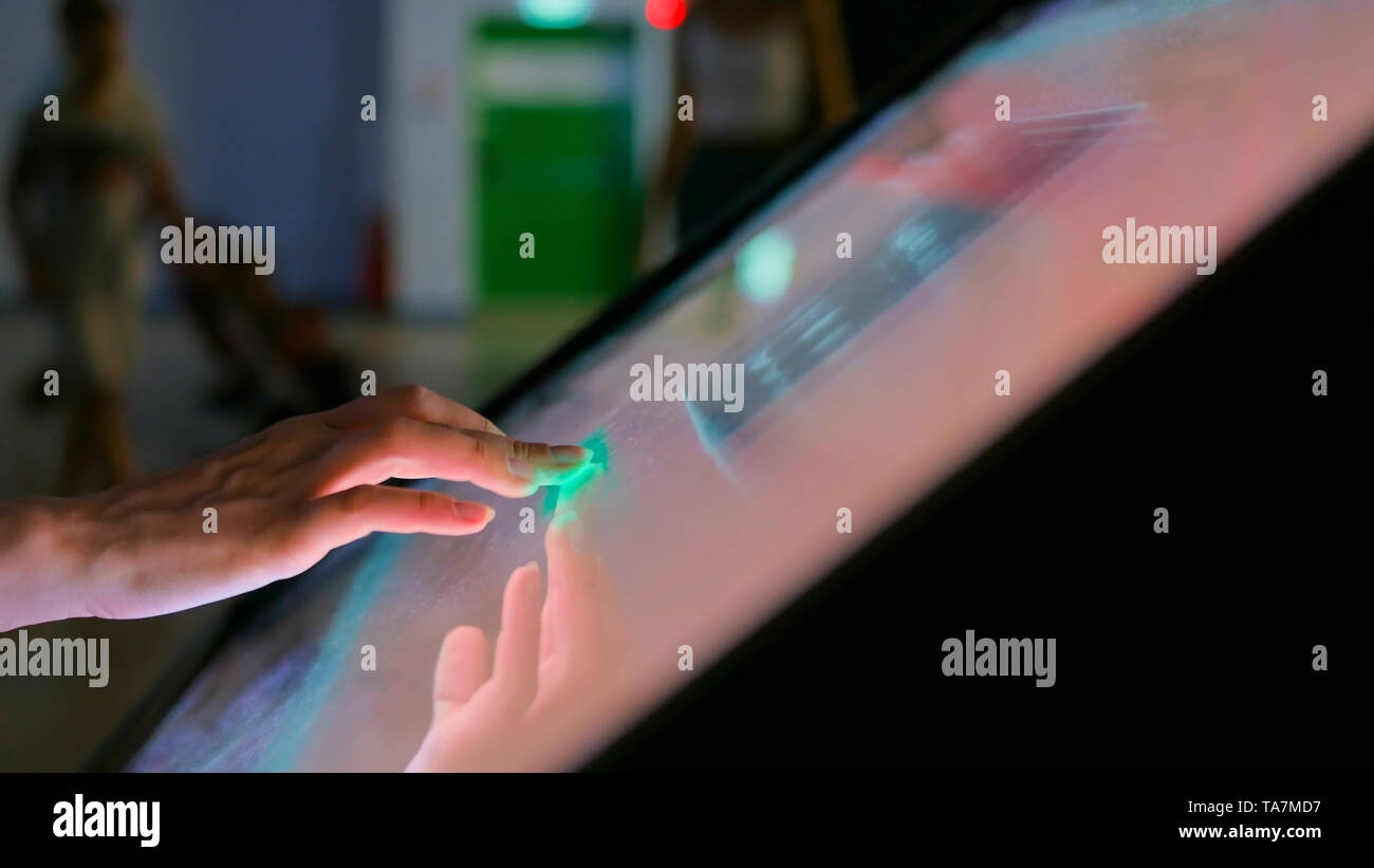 Woman using interactive touchscreen display at modern museum Stock ...