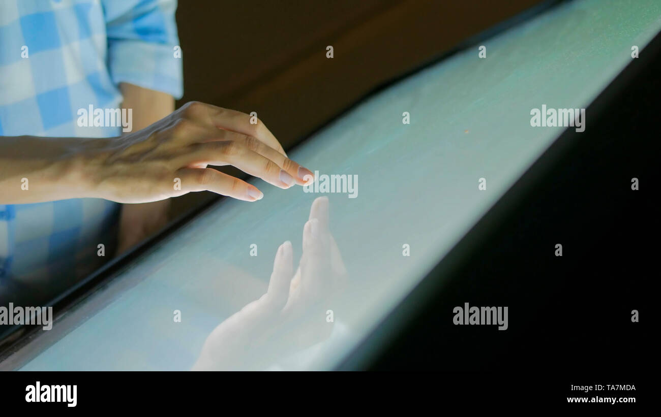 Woman using interactive touchscreen display at modern museum Stock ...