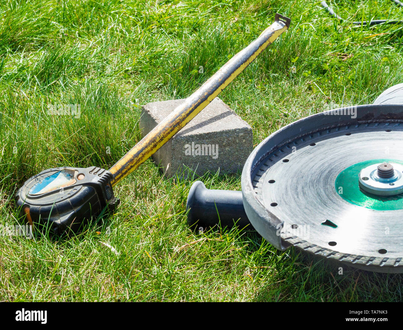 pavement Stone are laying on grass. Work tools, measure ruler and saw ...