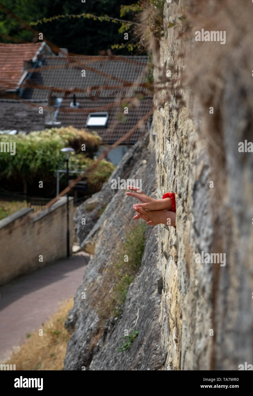 Hands of a child through brick wall of medieval castle Stock Photo - Alamy