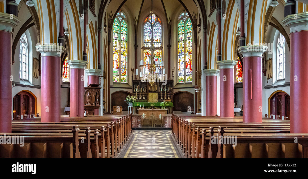 Inside a cathedral of catholic church with stained glass and candles ...