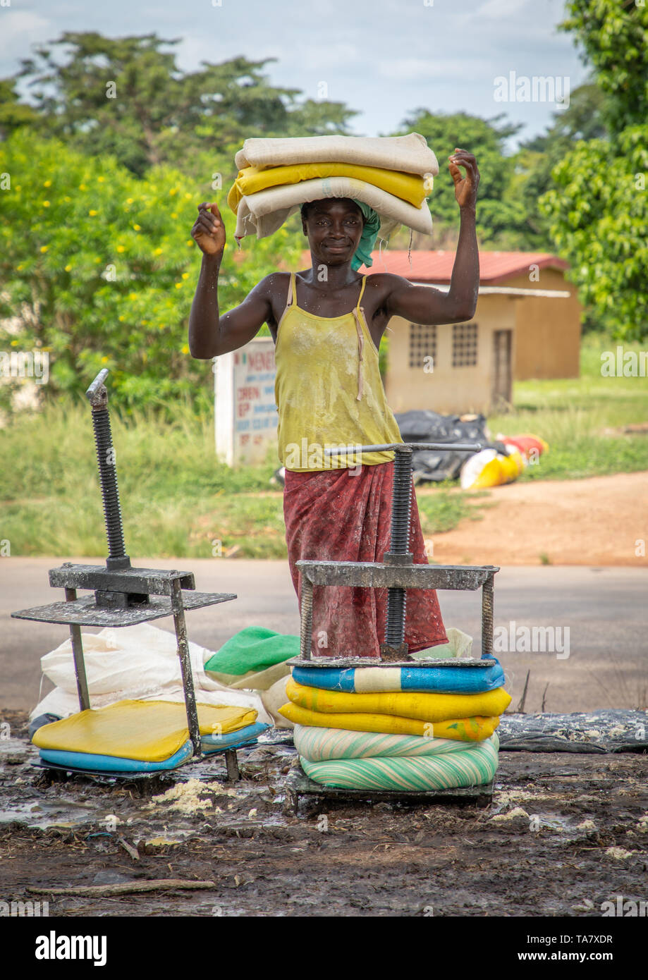 African woman putting attiéké in bags, Région des Lacs, Sakiare, Ivory ...