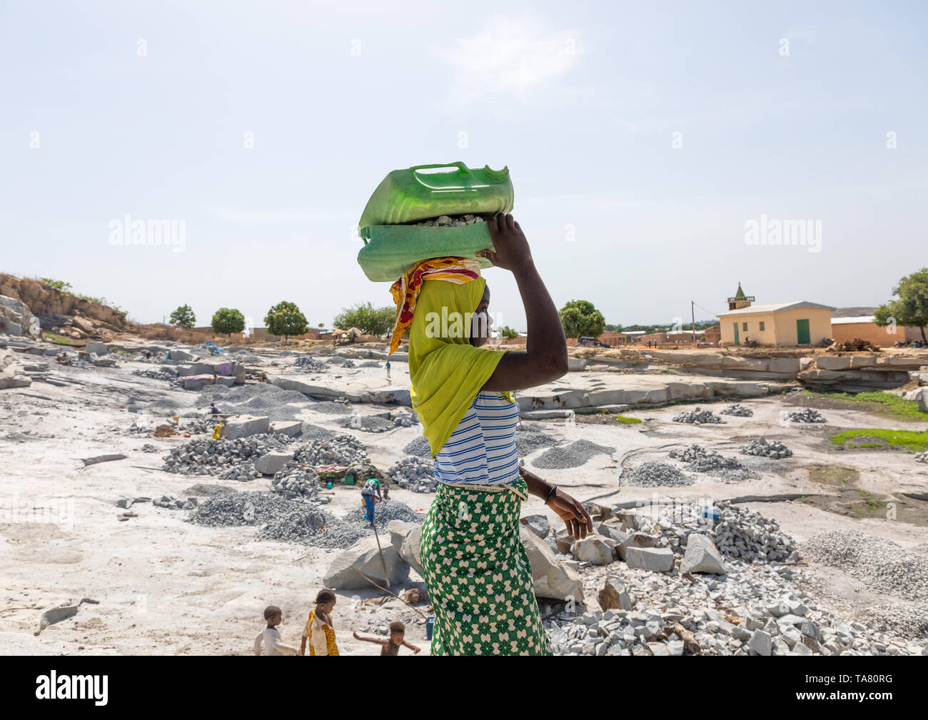 African women carrying stones in a granite quarry, Savanes district ...