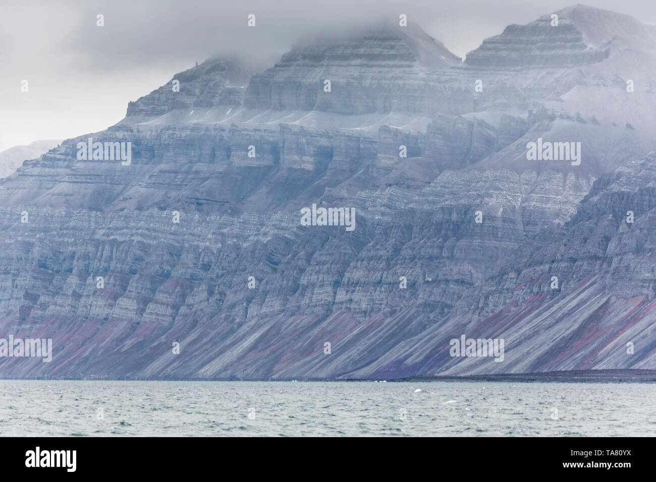 Billon year old jagged rock formations with different green moss and ...