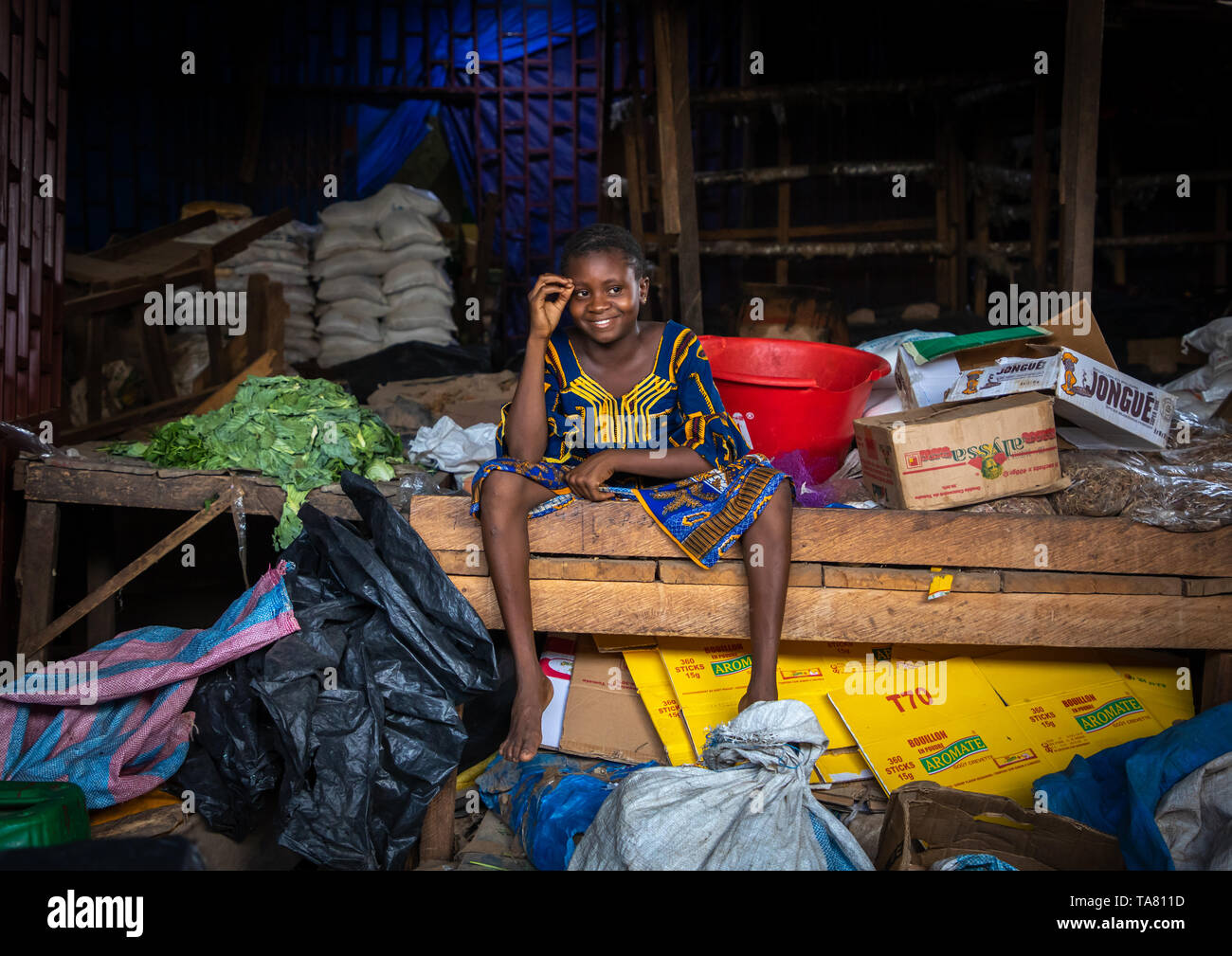 African girl sit in a market stall, Poro region, Korhogo, Ivory Coast ...