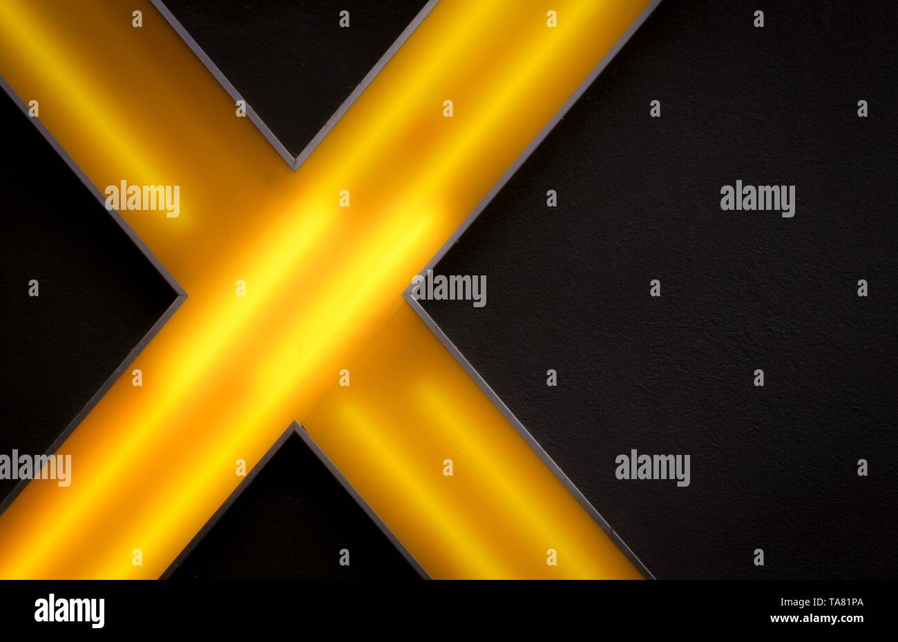 Back-lighted yellow abstract cross on black wall Stock Photo - Alamy