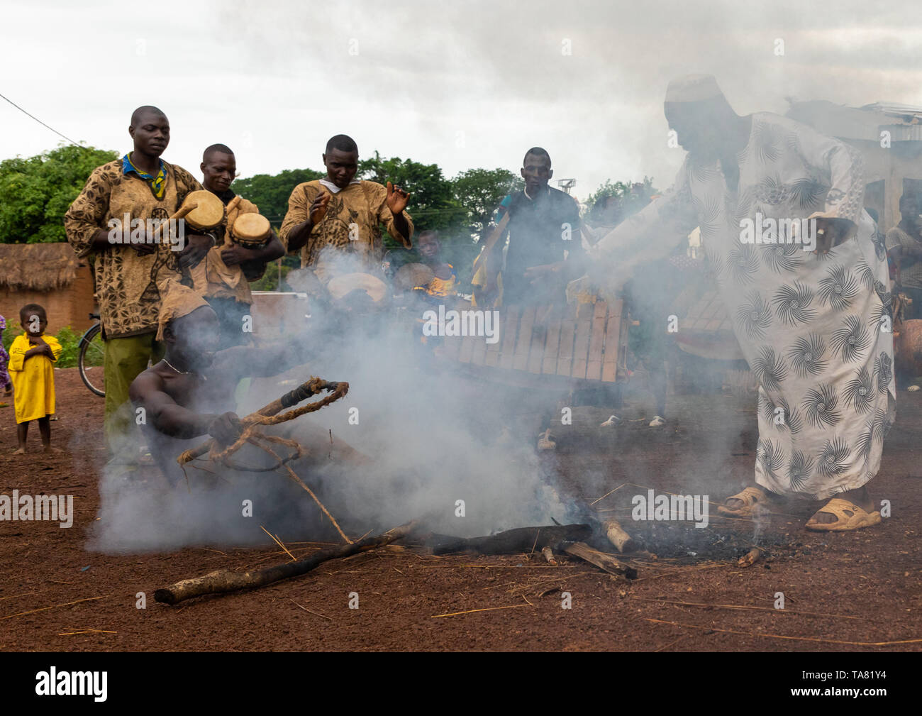 Shirtless man sitting in the fire during the Ngoro dance, Savanes ...