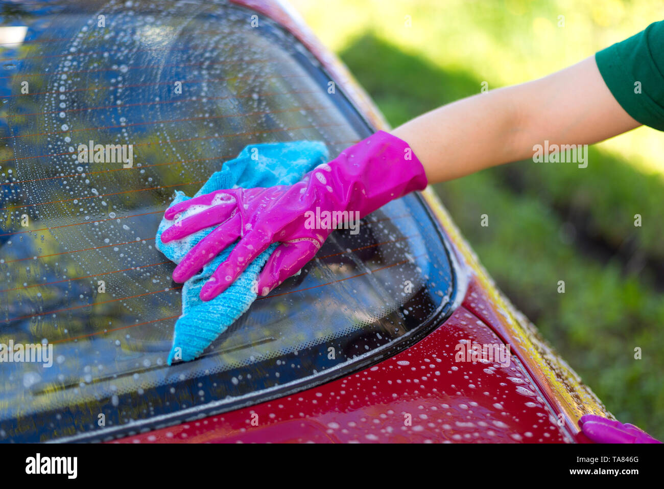 Woman in rubber gloves washes a red car. Cleaning detergent Stock Photo ...