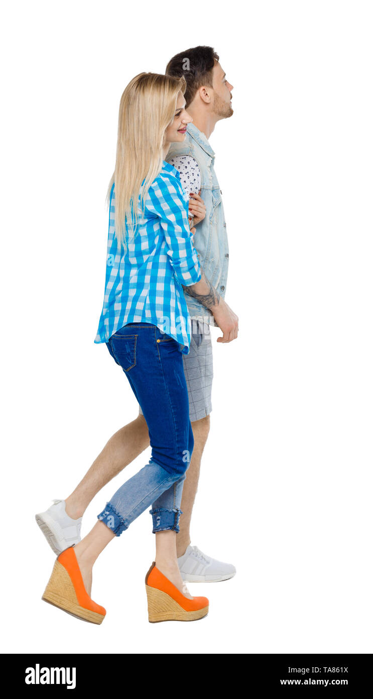 Side view of going couple. walking friendly girl and guy holding hands ...