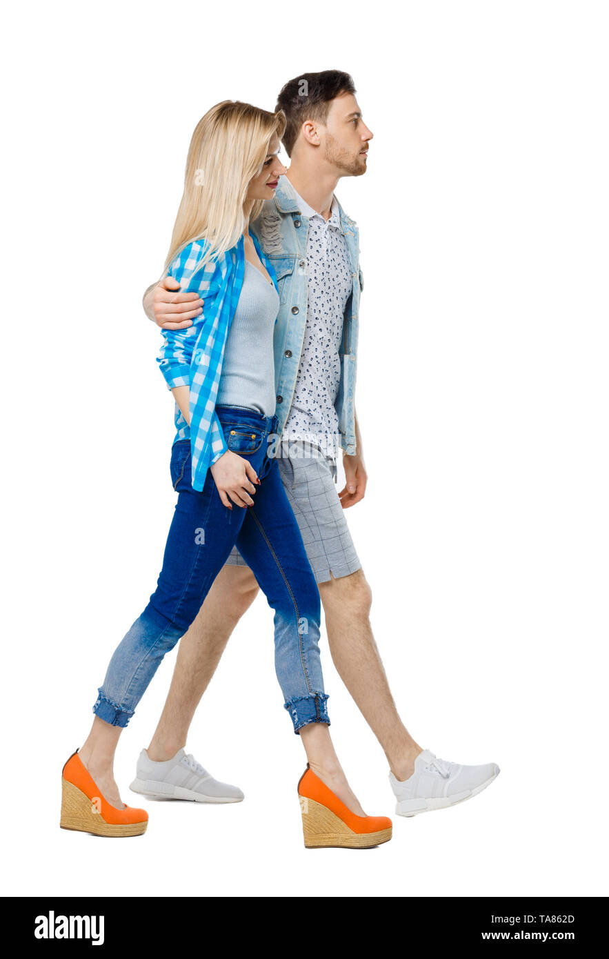 Side view of going couple. walking friendly girl and guy holding hands ...