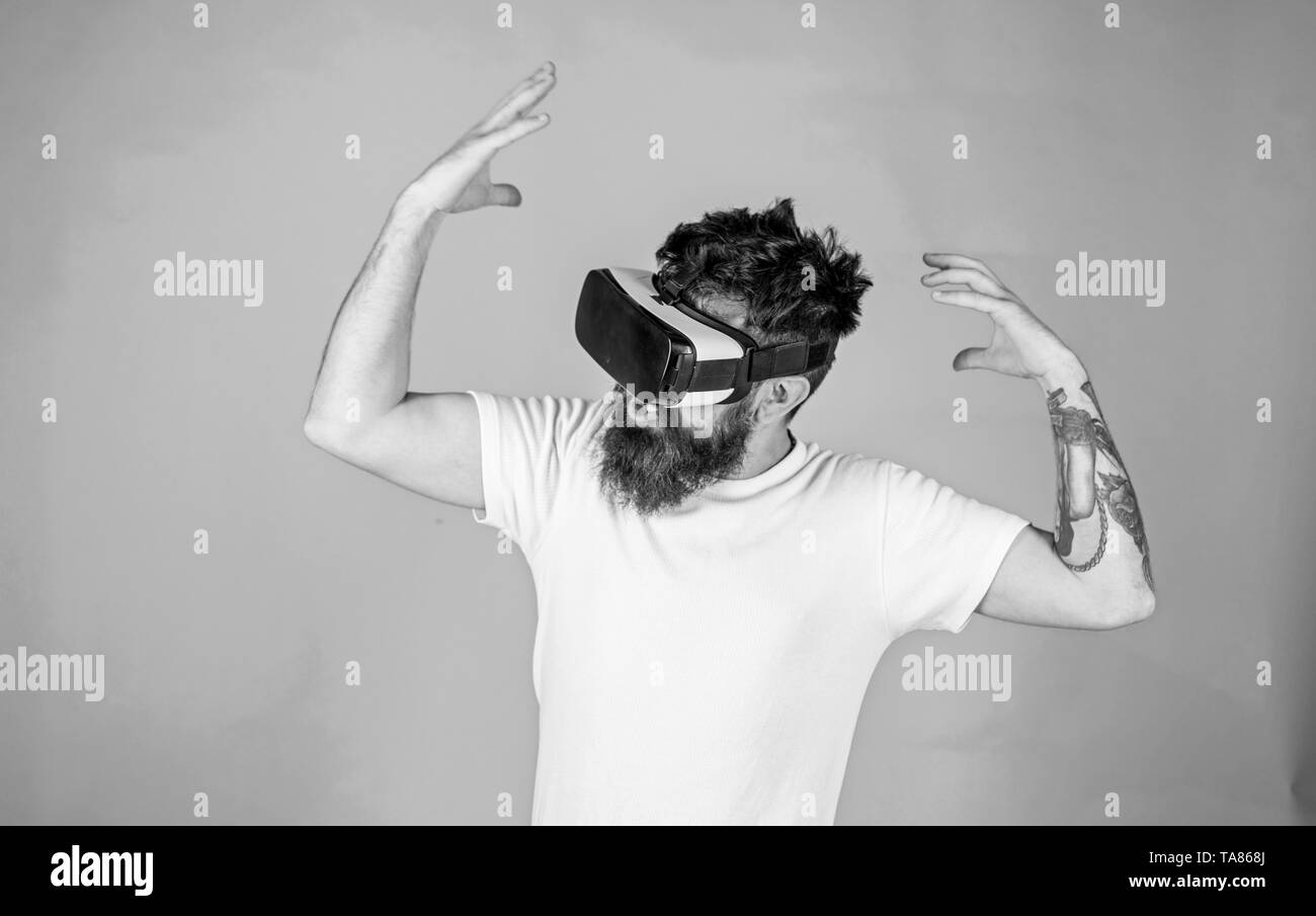 Hipster with inspired expression exploring VR with modern gadget. VR gadget concept. Guy with ...