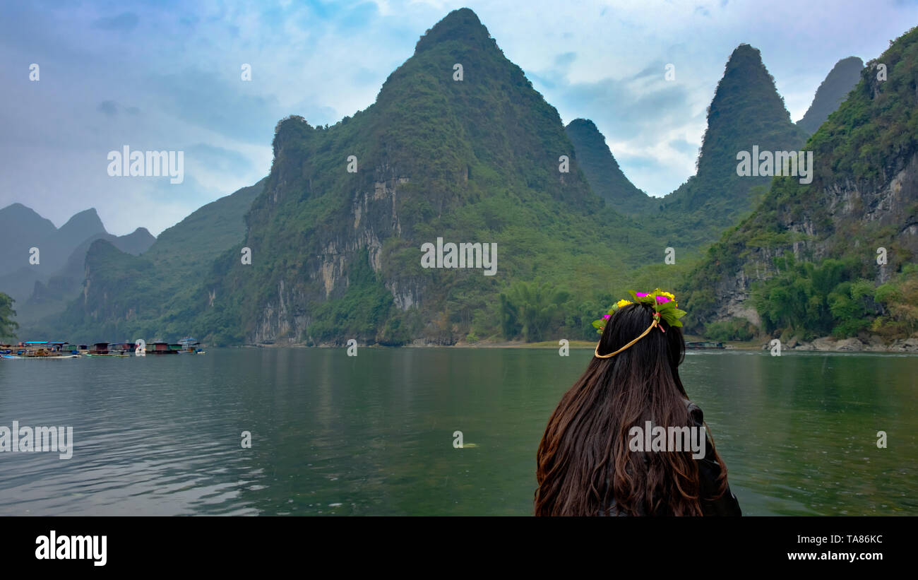 A long hair girl with Flowers on her head, photographed from the back ...