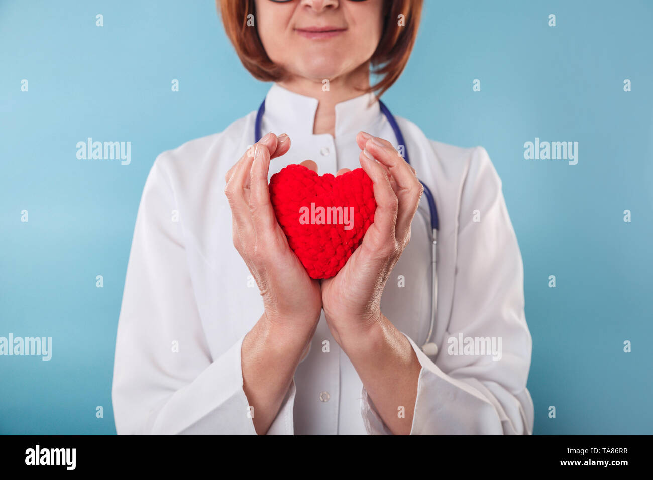 Medicine doctor holding red heart shape in hand on blue background ...