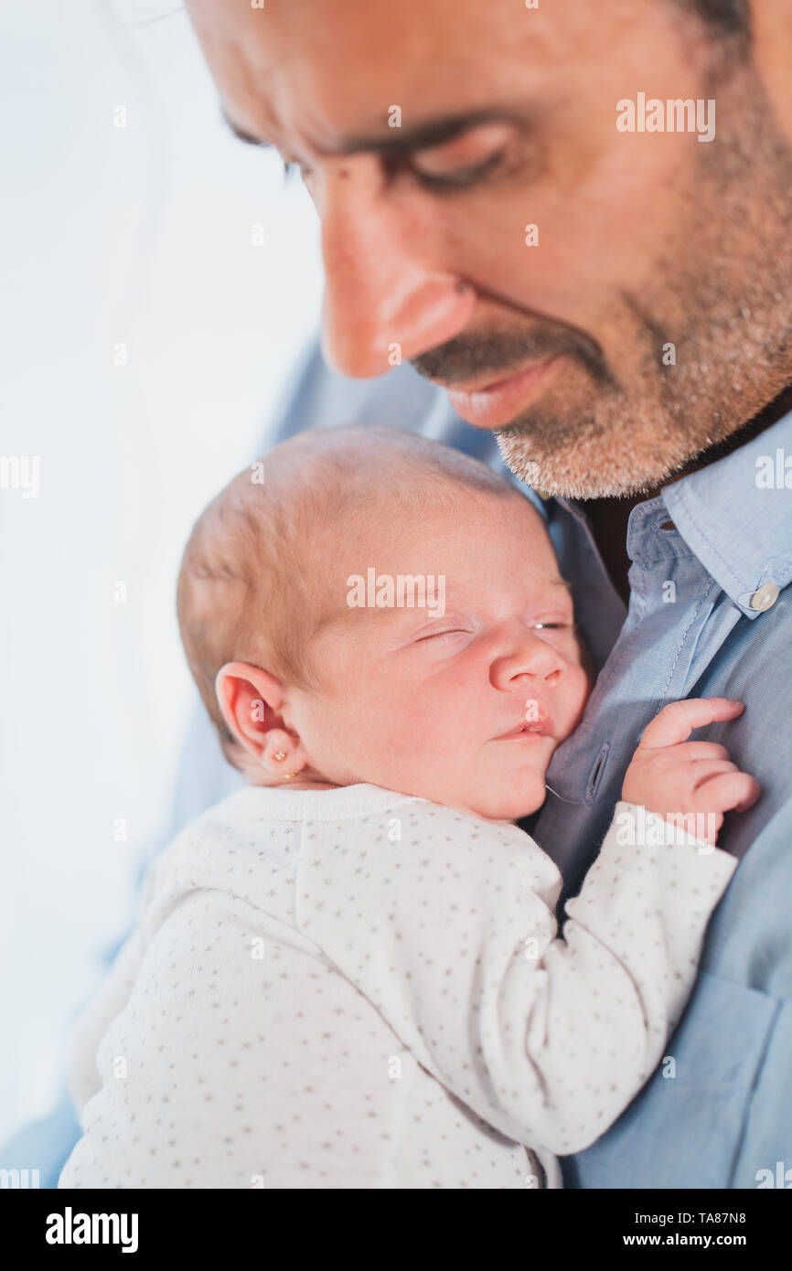 New father sleeping his cute adorable newborn on his lap. Baby ...