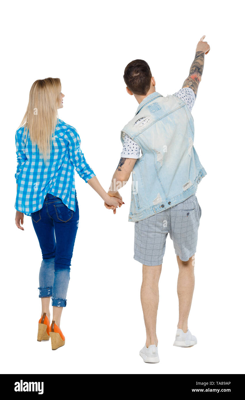 Back view of the couple walking and pointing upwards. Rear view people ...