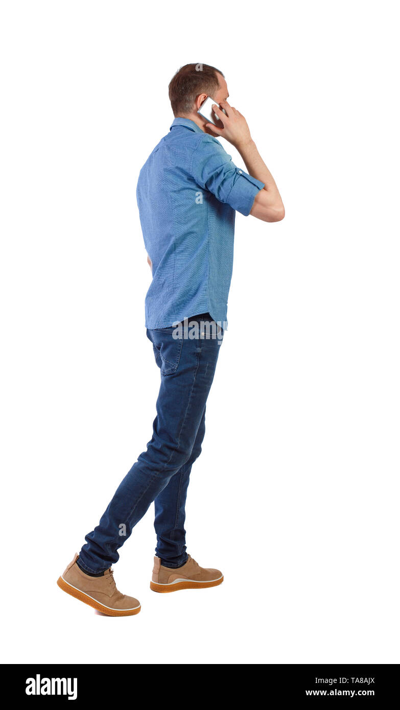 backview of man walking with a mobile phone. backside view of person ...
