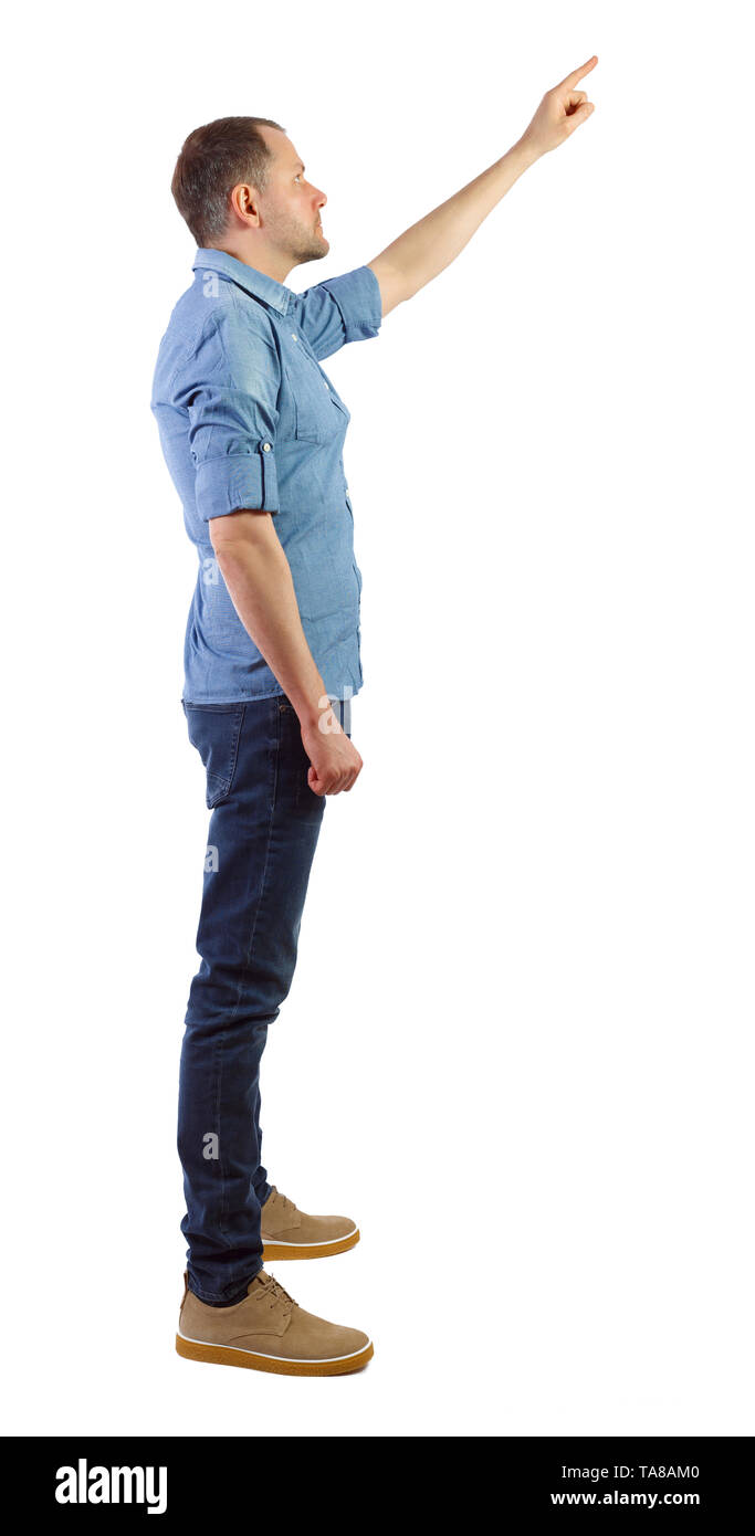 Side view of a man in jeans points his hand upwards. Rear view people ...